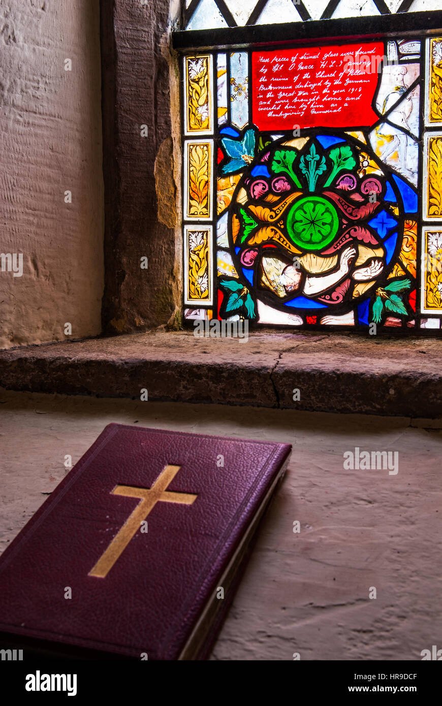 The bible on display in a church window set against a stained glass ...