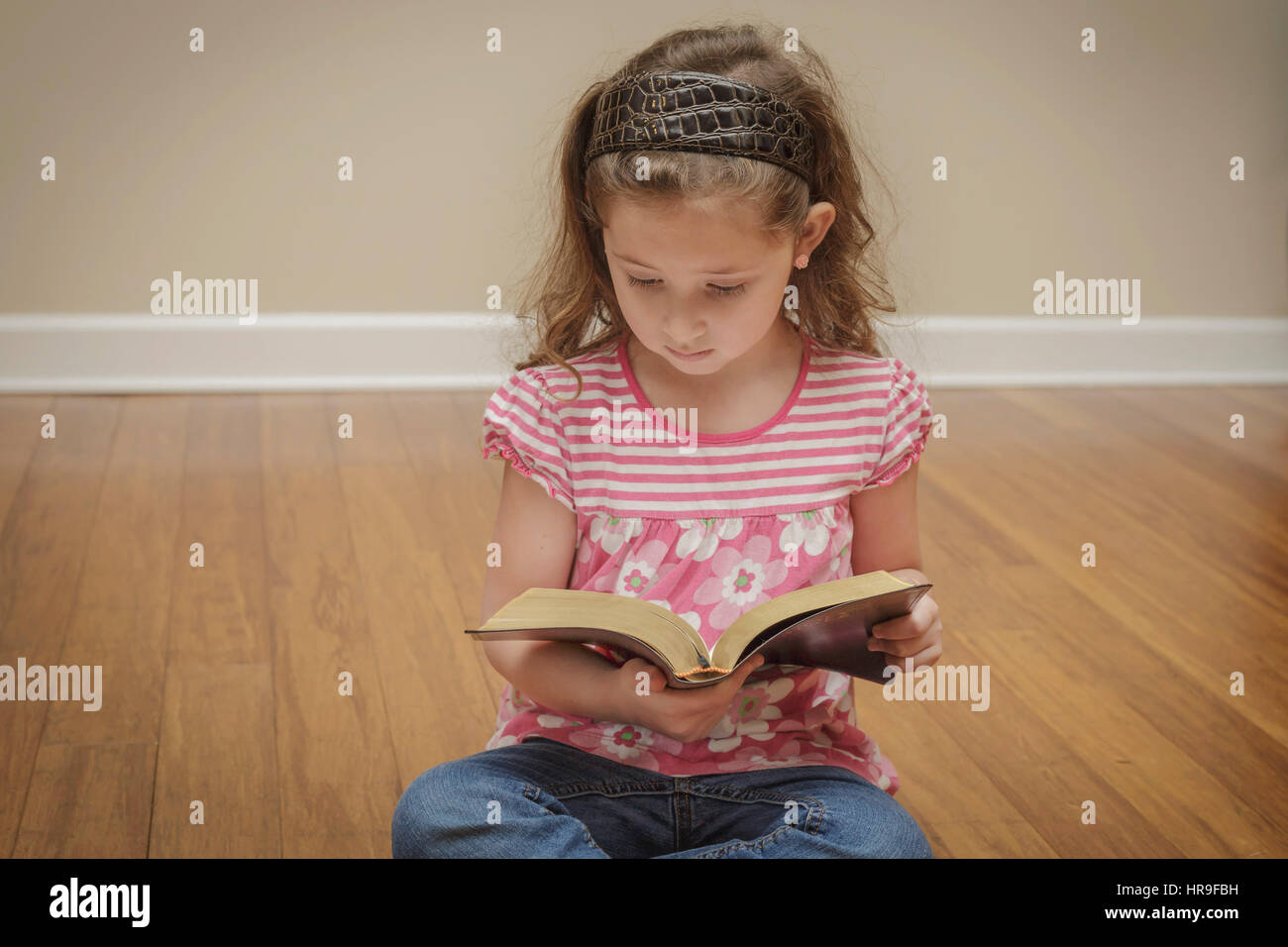 young girl sitting reading a book Stock Photo - Alamy