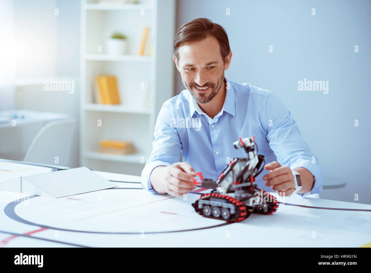 Positive engineer testing robot Stock Photo - Alamy