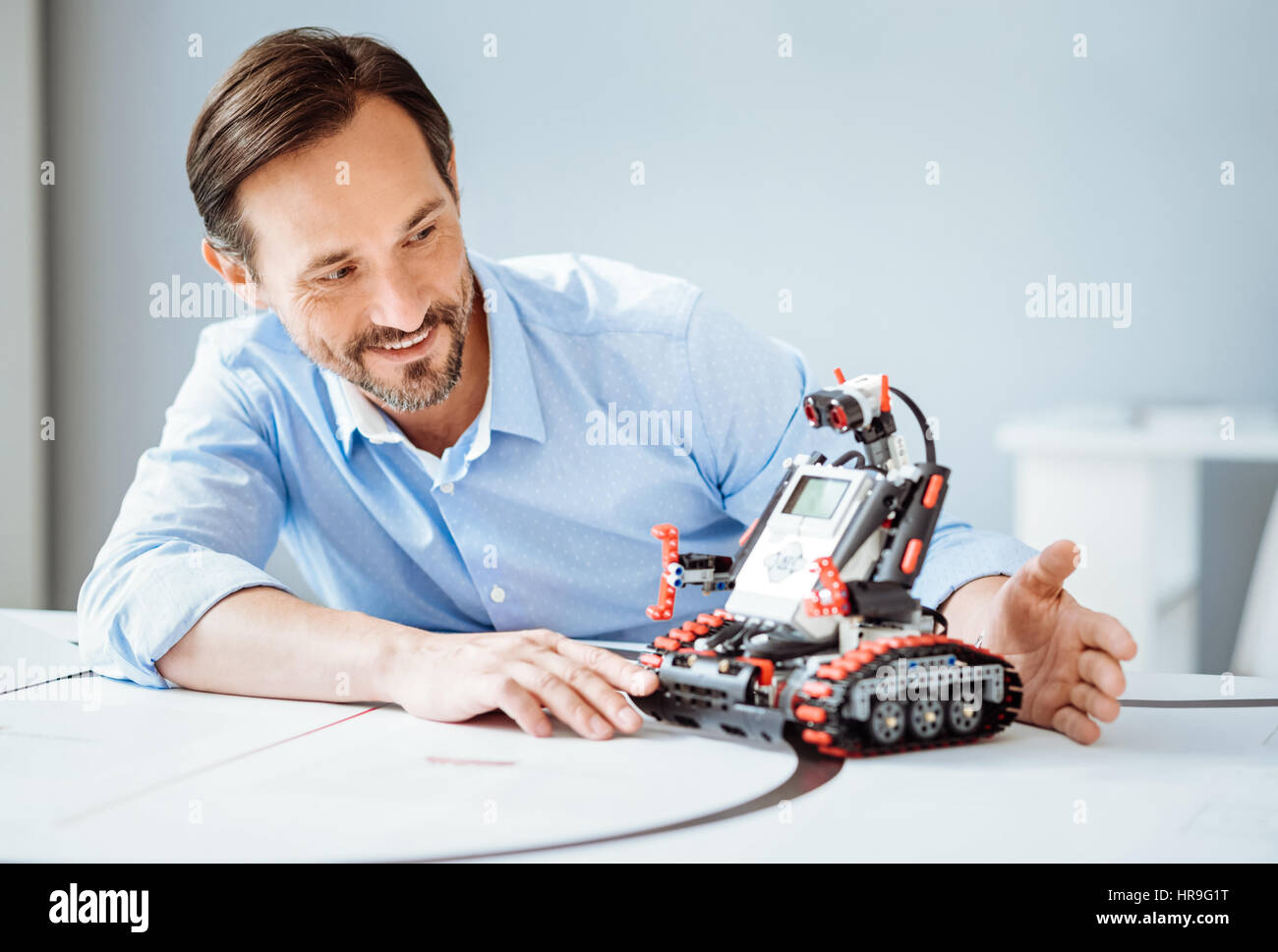 Positive man using robot Stock Photo - Alamy