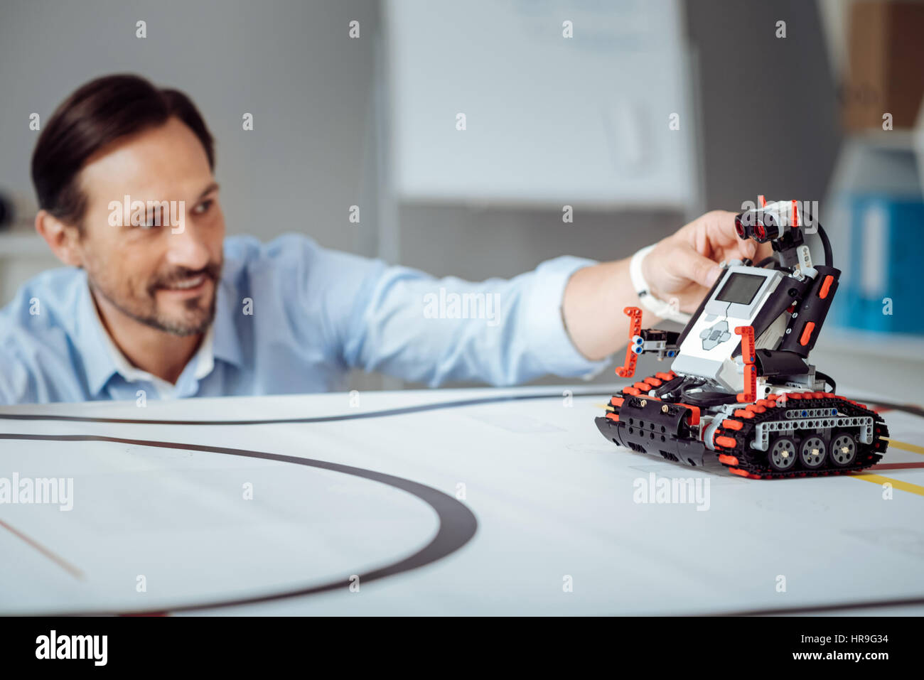 Positive professional engineer testing the robot Stock Photo - Alamy