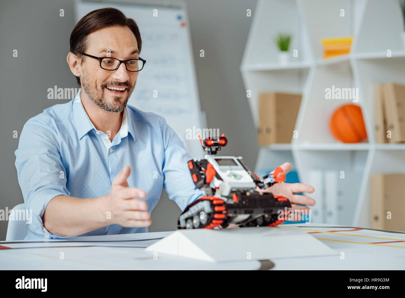 Cheerful engineer testing the robot Stock Photo - Alamy
