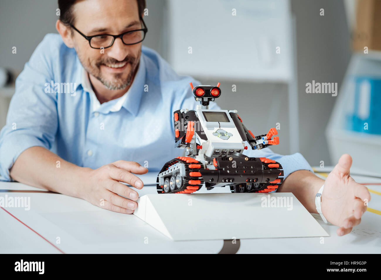 Positive adult engineer testing the robot in a lab Stock Photo - Alamy
