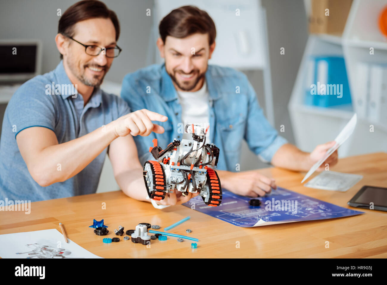 Positive engineers examining the robot Stock Photo - Alamy