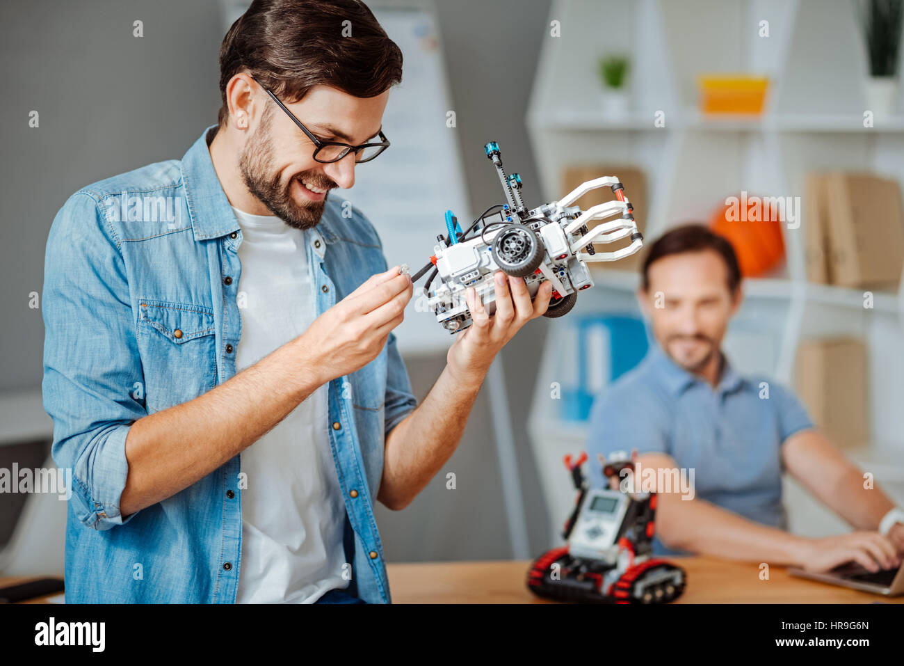 Cheerful engineer constructing the robot Stock Photo - Alamy