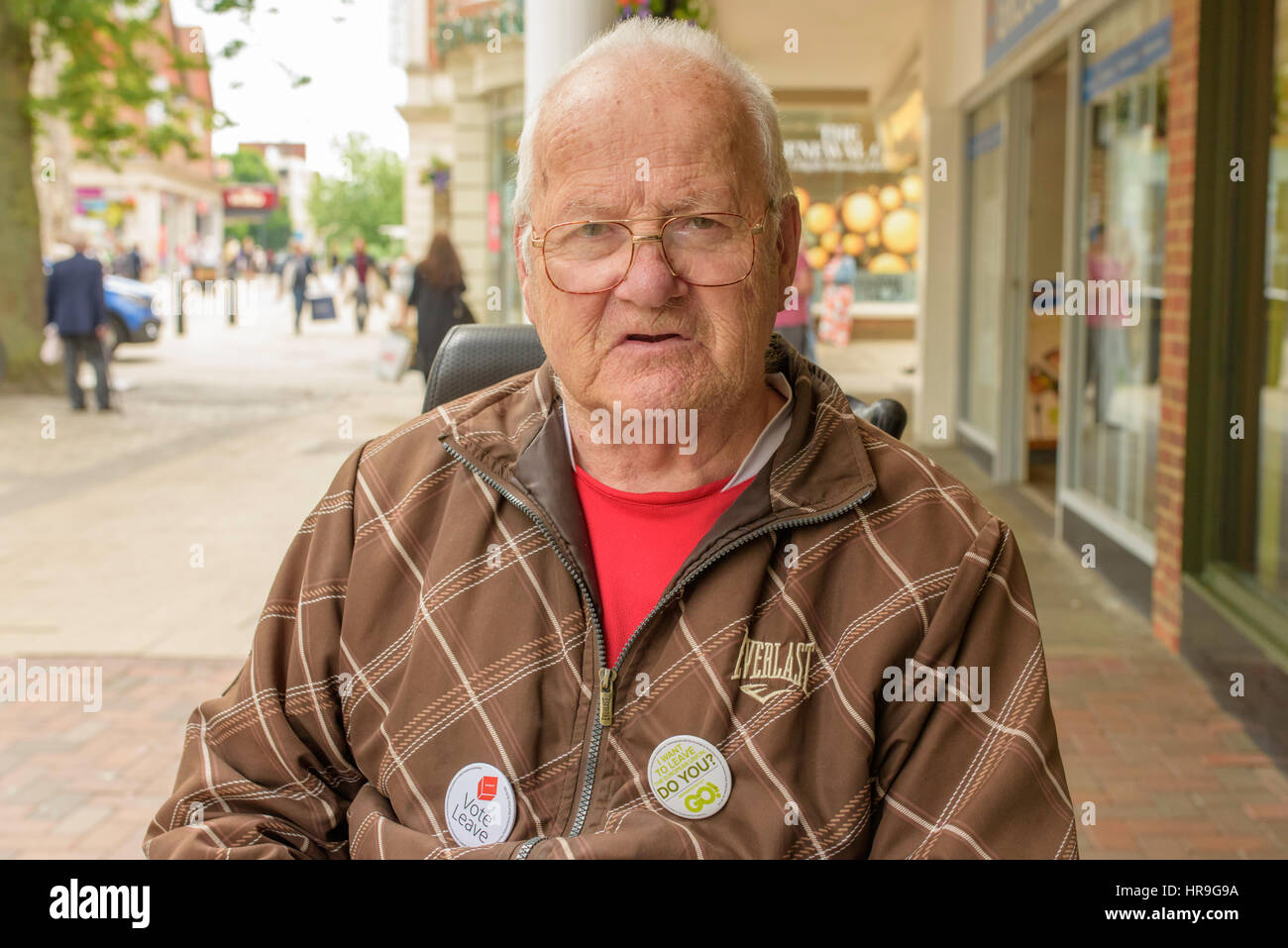 A mature man in a wheelchair displaying badges backing the Vote Leave ...