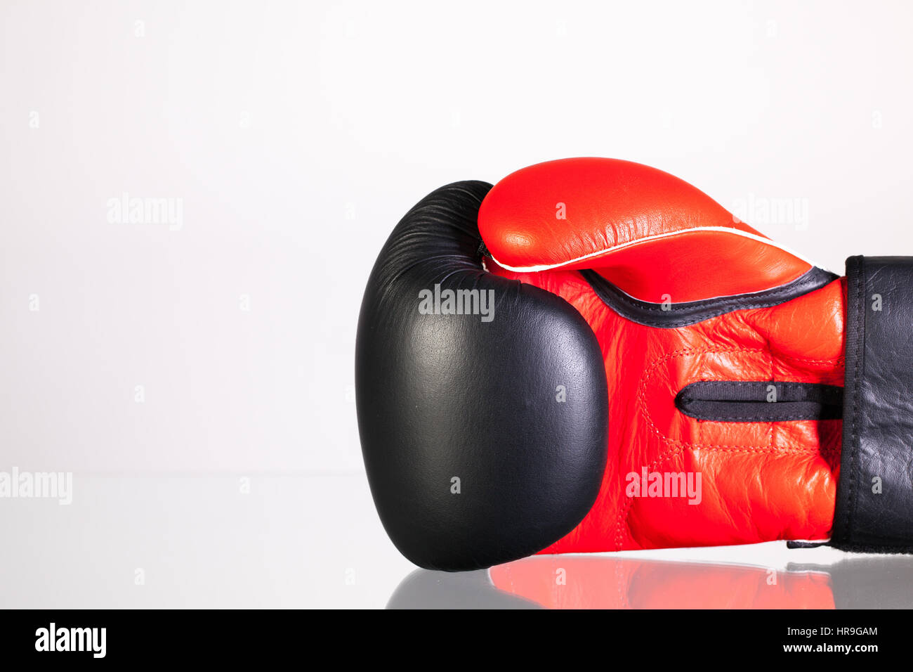 Red and black boxing gloves on a glass table isolated on white ...
