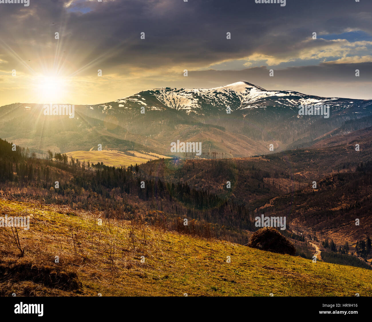 Stack of hay on hillside meadow in mountain area in early spring ...