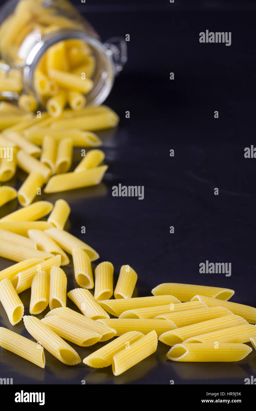 Italian Penne Rigate Macaroni Pasta isolated on black rock texture ...
