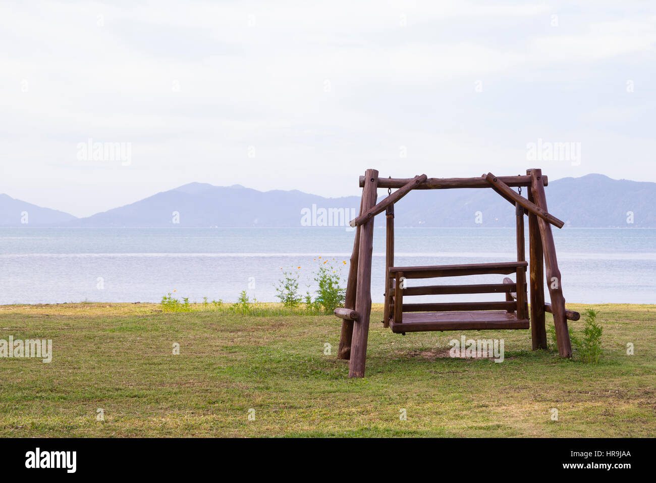 Wooden swing on the green grass field by the sea Stock Photo - Alamy