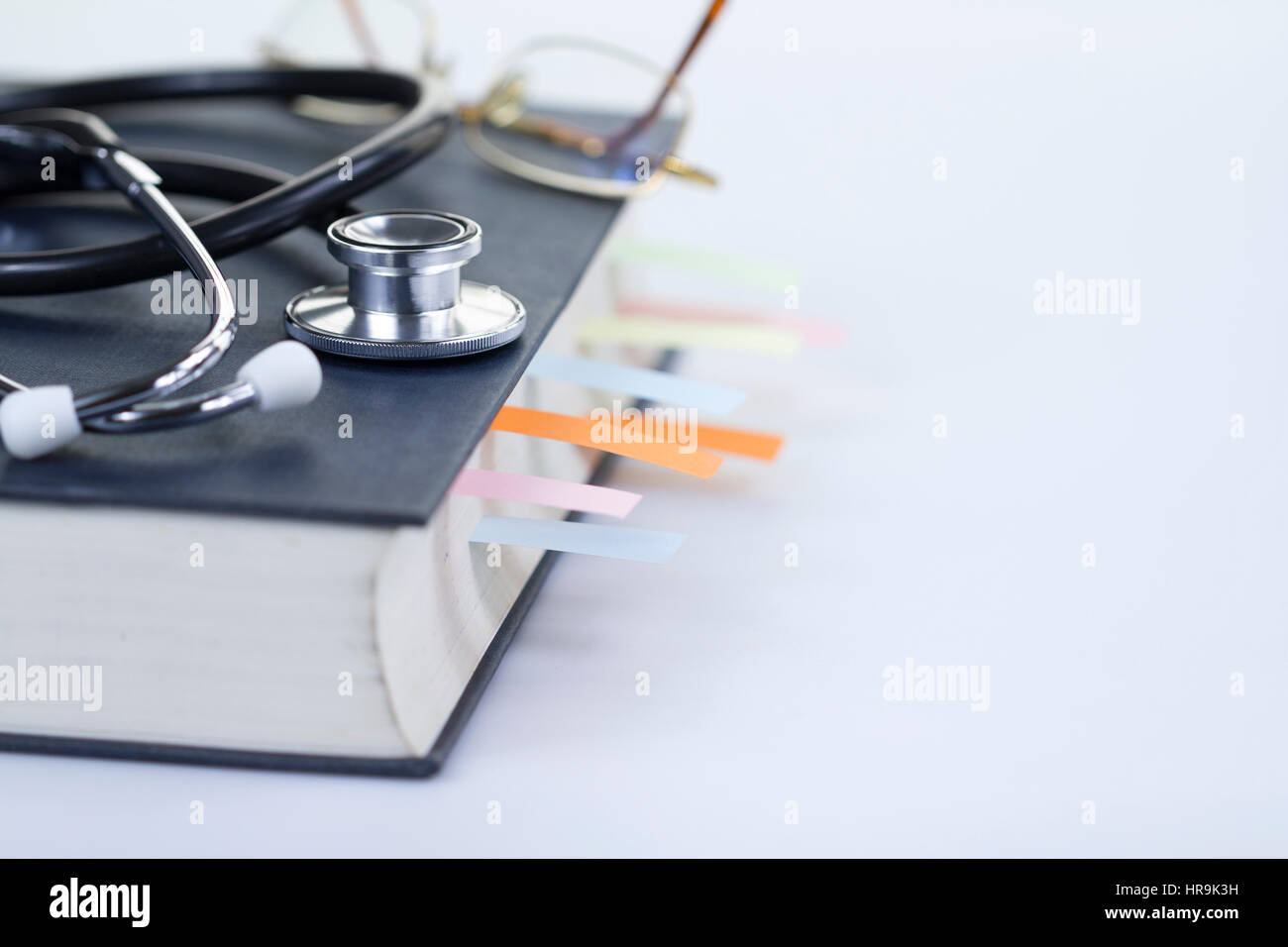 Medical student textbook with multicolor bookmarks and stethoscope ...