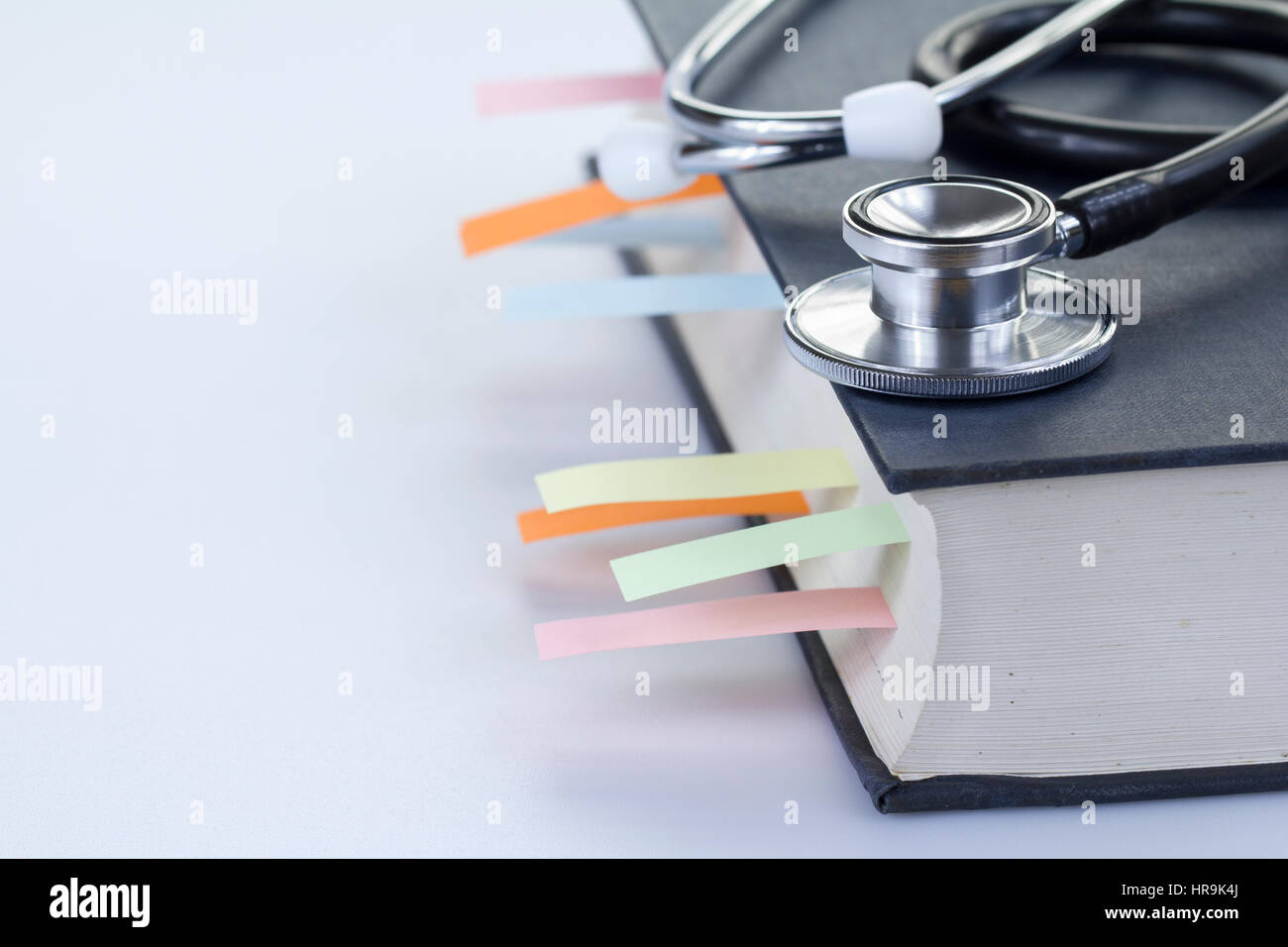 Medical student textbook with multicolor bookmarks and stethoscope ...