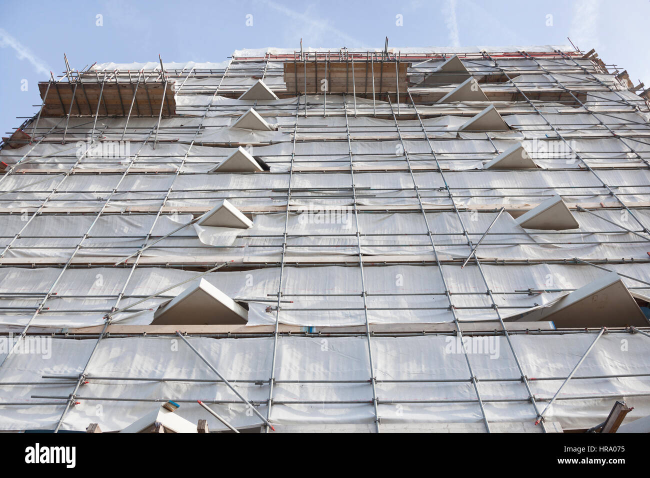 white cloth on scaffolding of high new building with concrete balconies ...