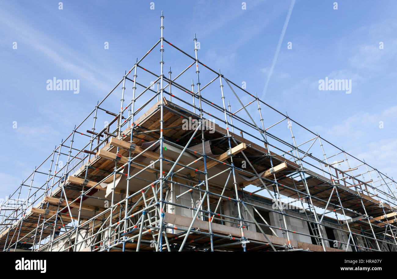 scaffolding on building site of new apartment building and blue sky in ...