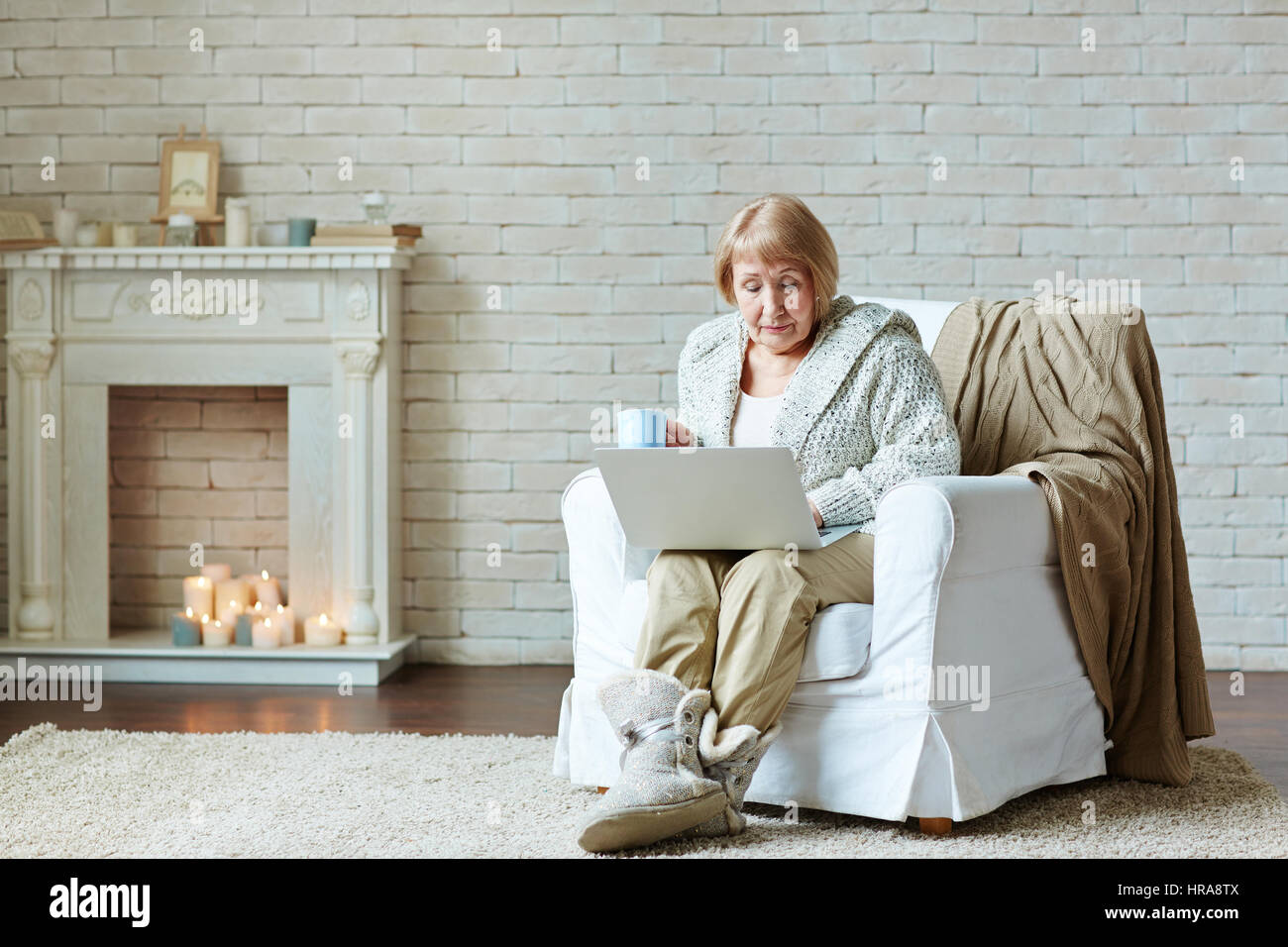 Retired woman in comfortable home clothing ensconced herself in ...