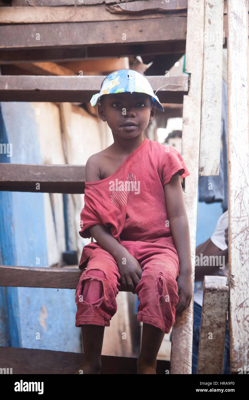 Young child sitting on the stairs of an orphanage in Kibera slums ...