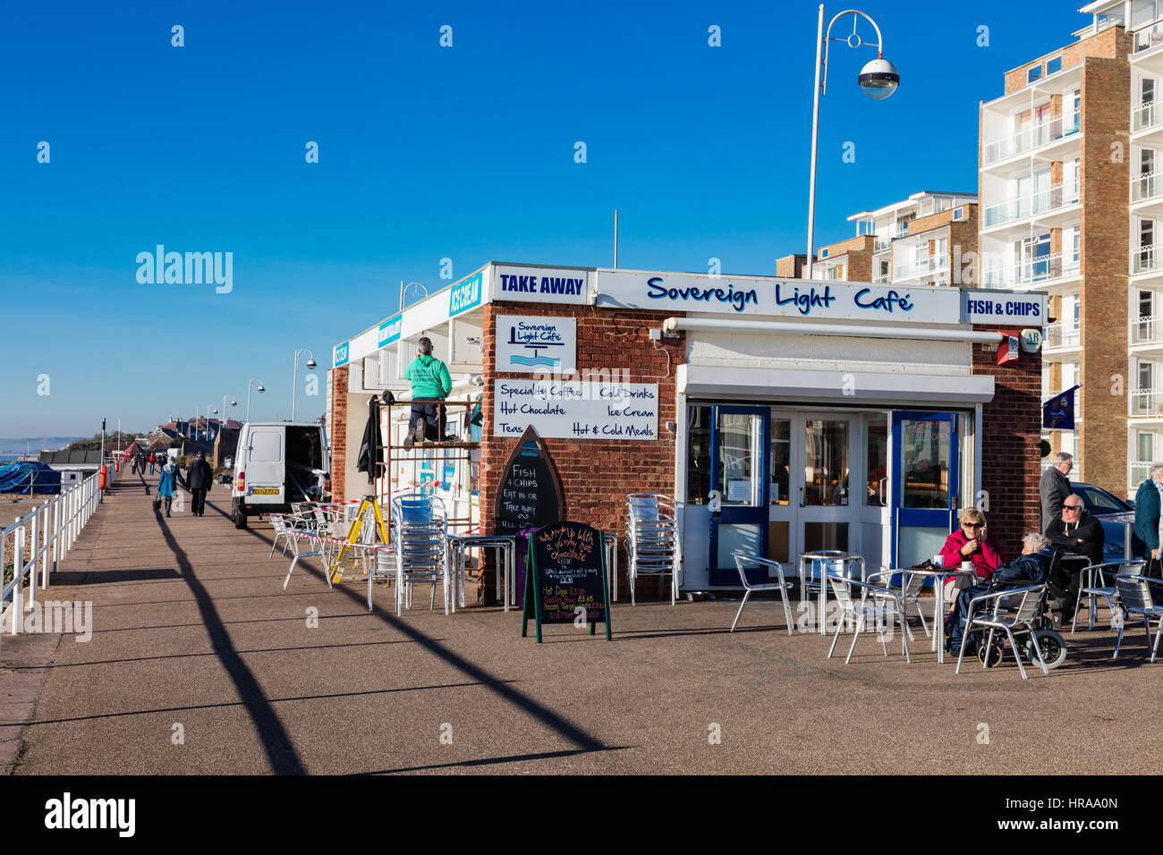 A carpenter works on the windows of The sovereign light cafe on the ...