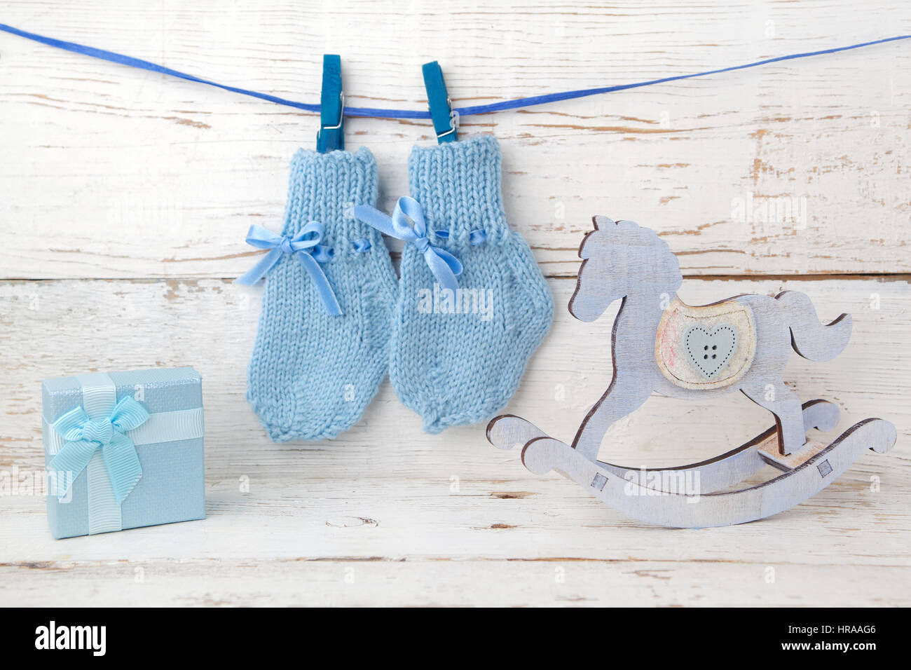 Blue booties for the baby on a wooden background of blue gift box and ...