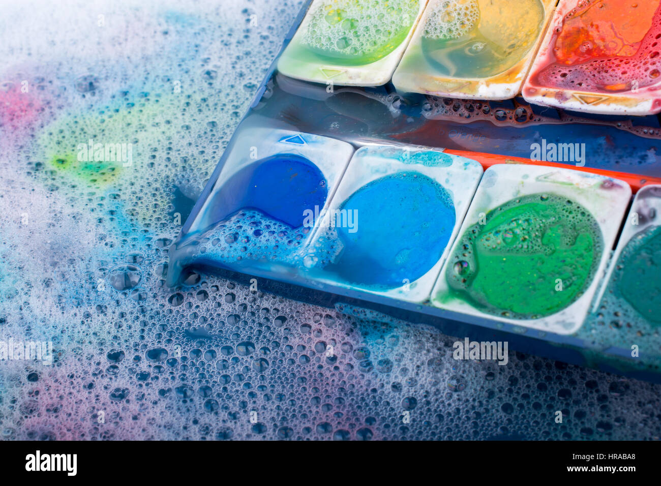 Watercolor paint dissolving in water covered with foam Stock Photo - Alamy