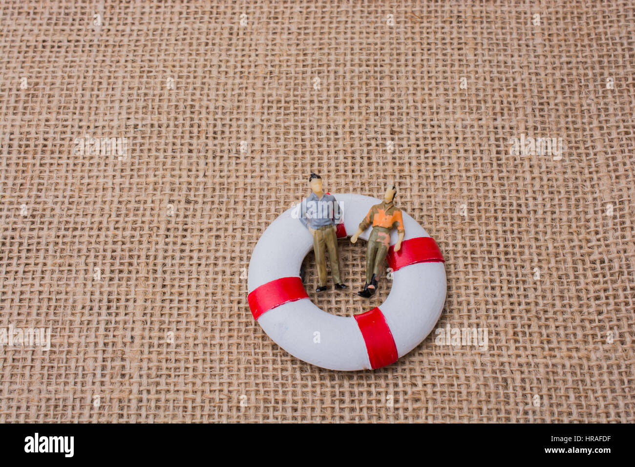 Little figurine men in a life preserver on life on canvas Stock Photo ...