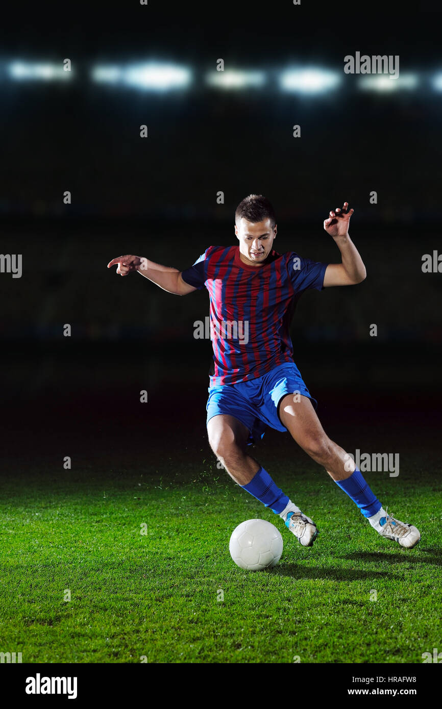 soccer player doing kick with ball on football stadium field isolated ...