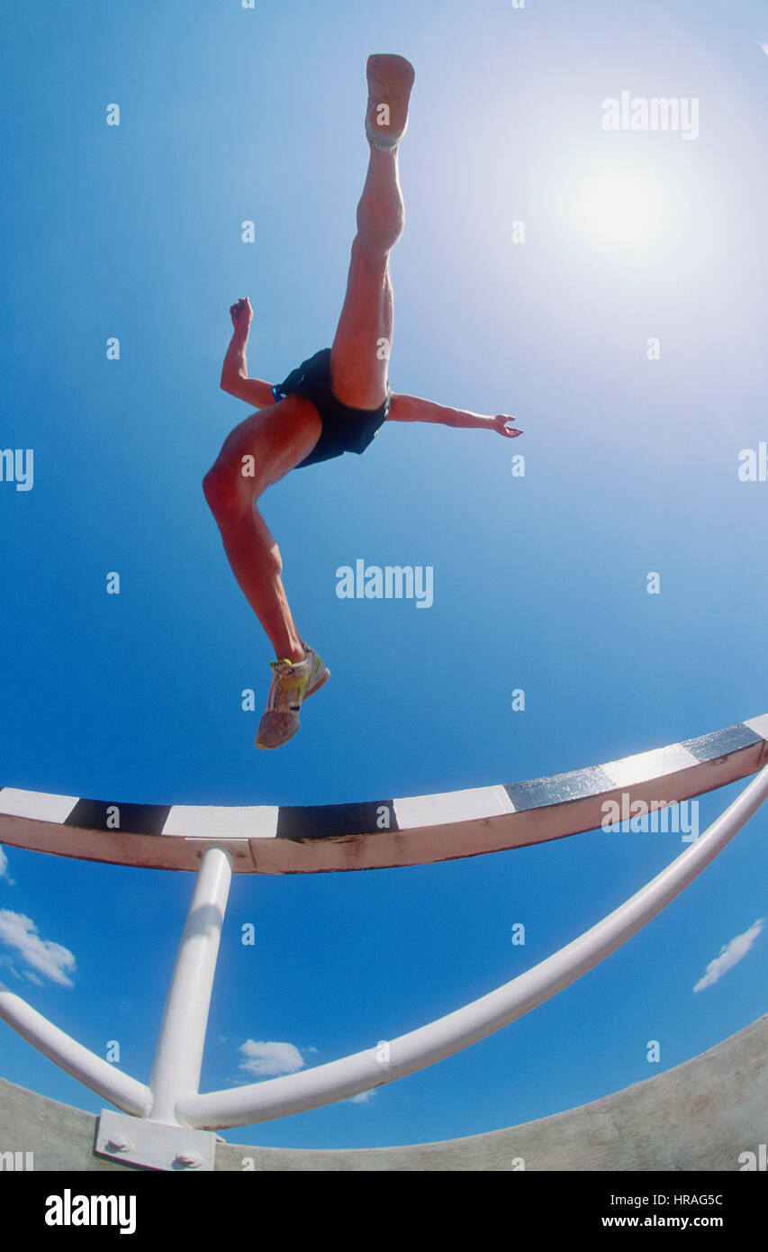 Low-Angle view of a man jumping over a barrier in a Steeplechase Stock ...