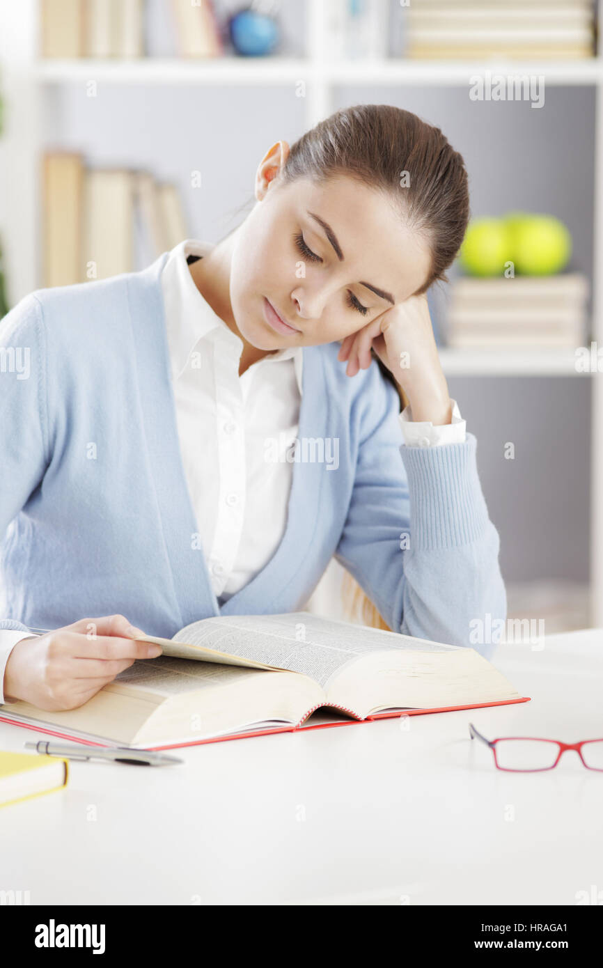 Beautiful female student reading a book Stock Photo - Alamy