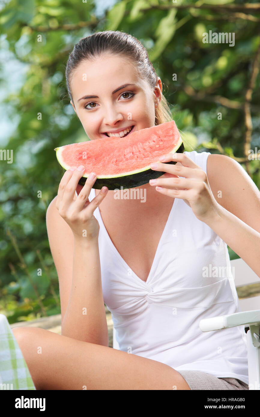 Portrait of a young woman eating watermelon Stock Photo - Alamy