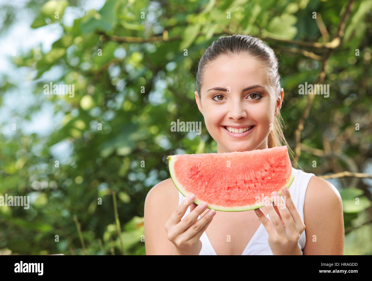 Portrait of a young woman eating watermelon Stock Photo - Alamy