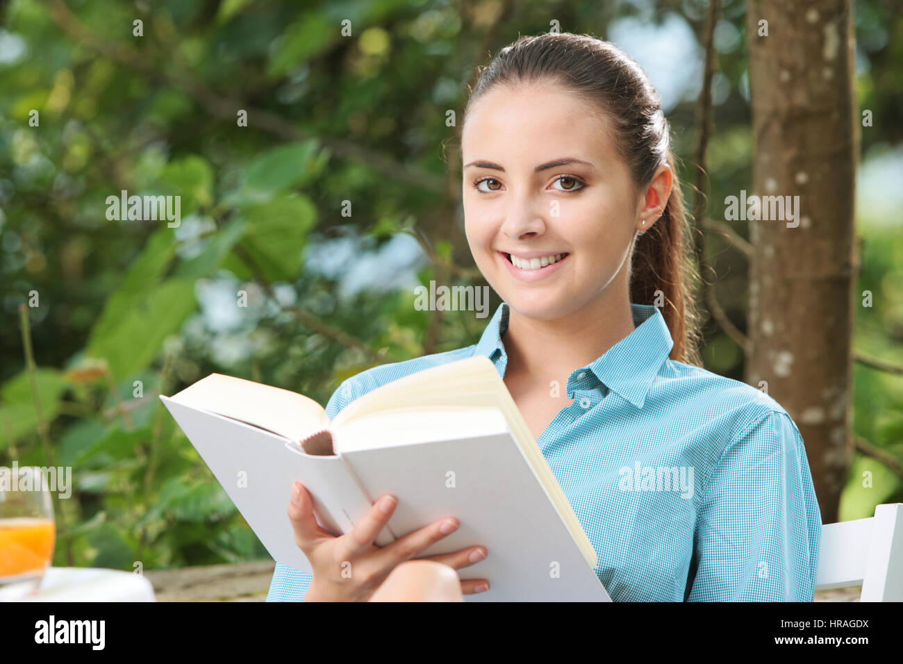 Portrait of Beautiful girl reading a book outdoors Stock Photo - Alamy
