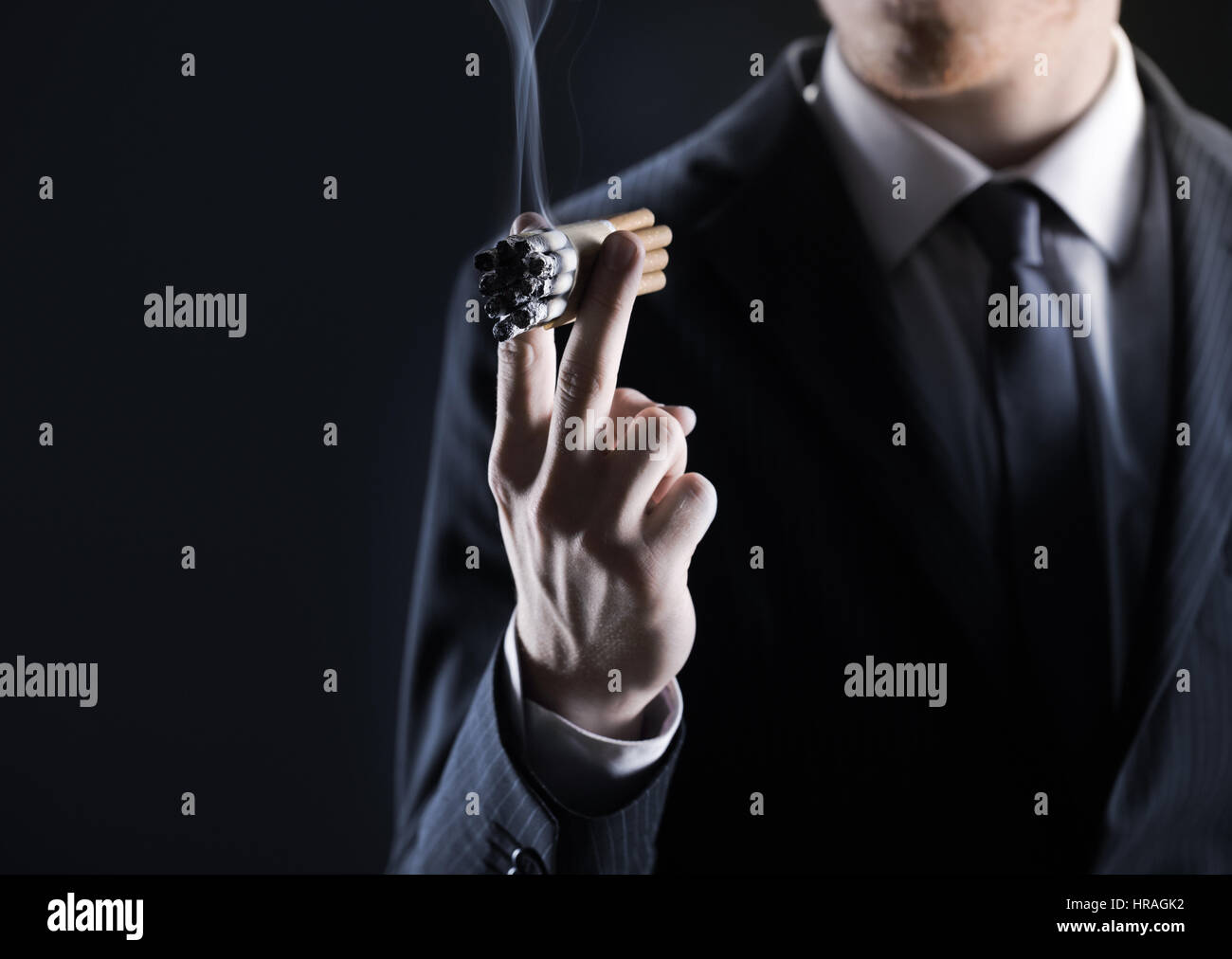 Cropped view of young man smoking many cigarettes Stock Photo - Alamy