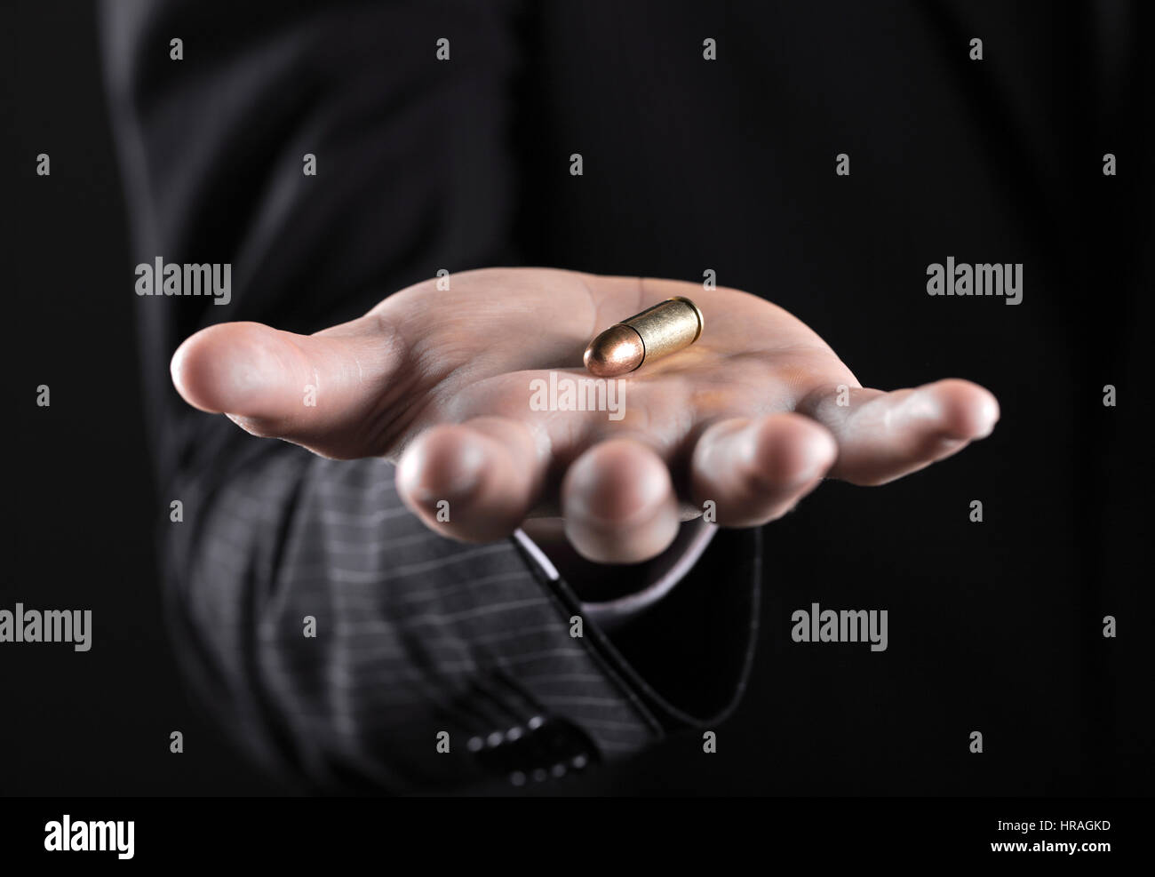 Male hand close up holding a bullet Stock Photo - Alamy
