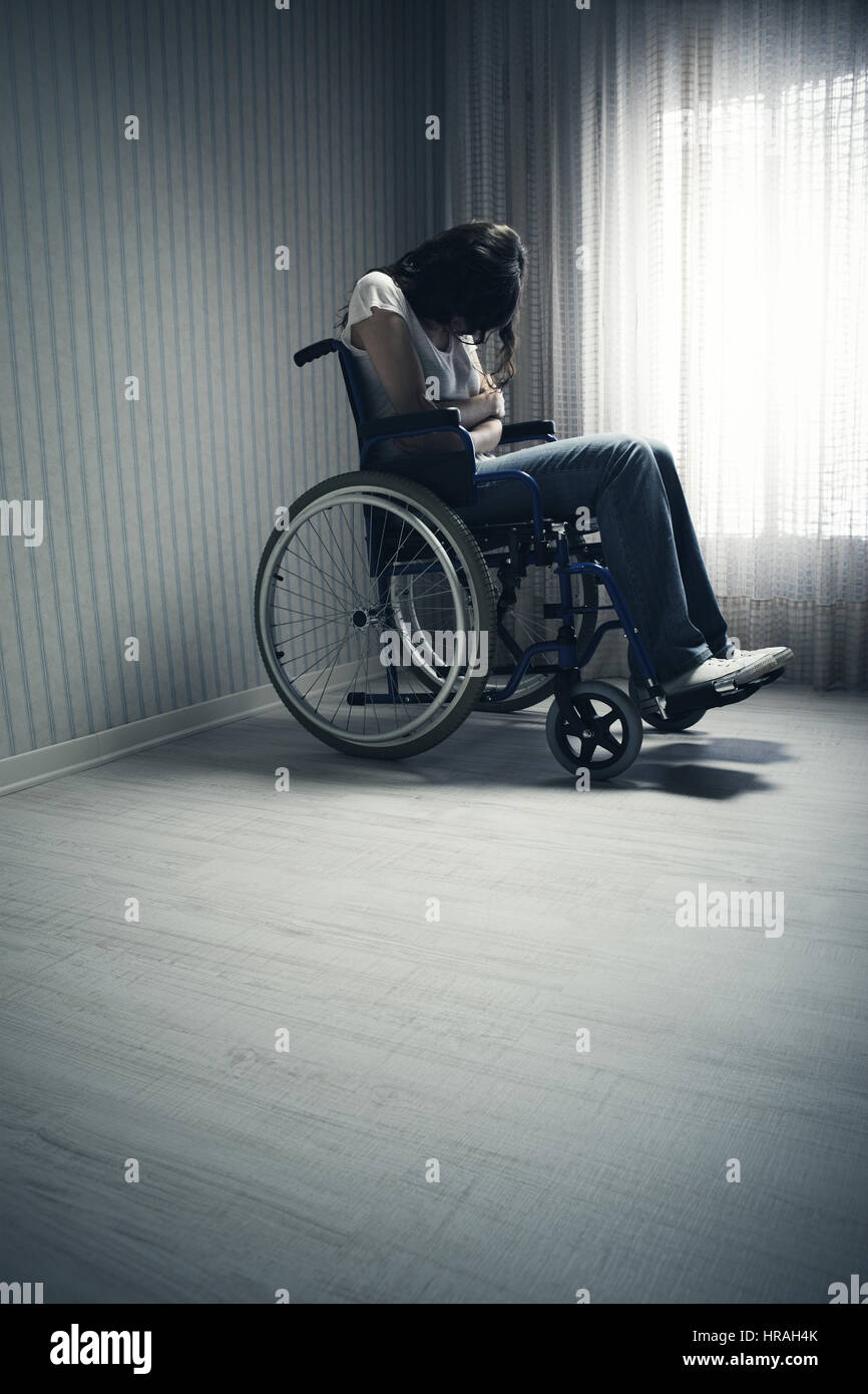 Crying woman sitting in wheelchair by window Stock Photo - Alamy