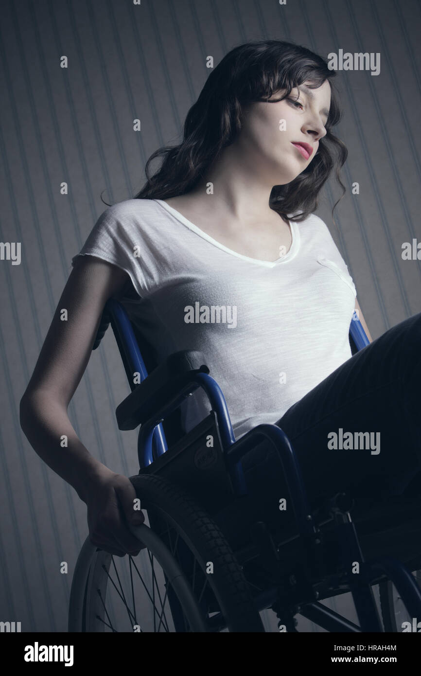 Sad woman sitting on wheelchair Stock Photo - Alamy
