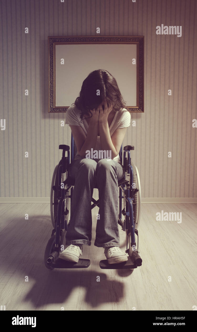 Crying woman sitting in wheelchair in empty room Stock Photo - Alamy