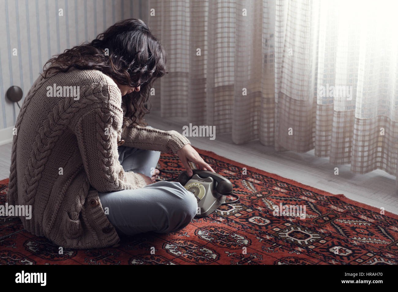 Sad woman sitting on the floor waiting for the phone call Stock Photo ...