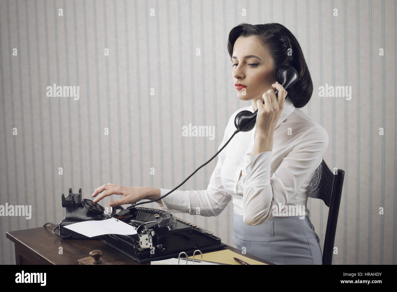 Perfect secretary talking on phone at desk Stock Photo - Alamy