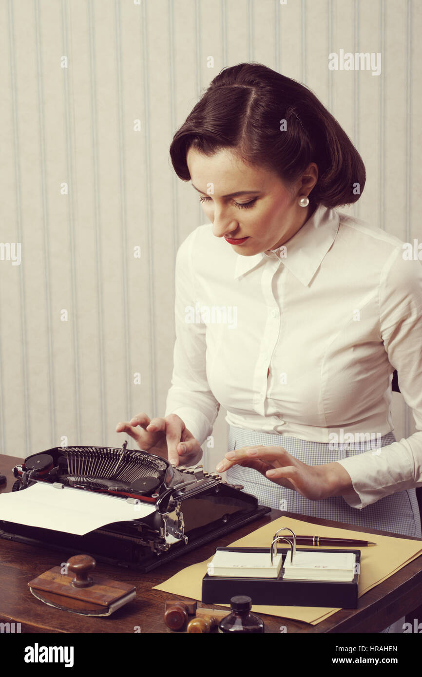 Retro business woman typing in her office Stock Photo - Alamy