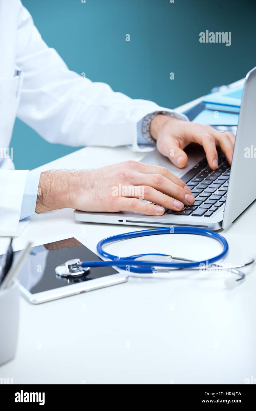 Doctor working at his desk with stethoscope, laptop and tablet Stock ...