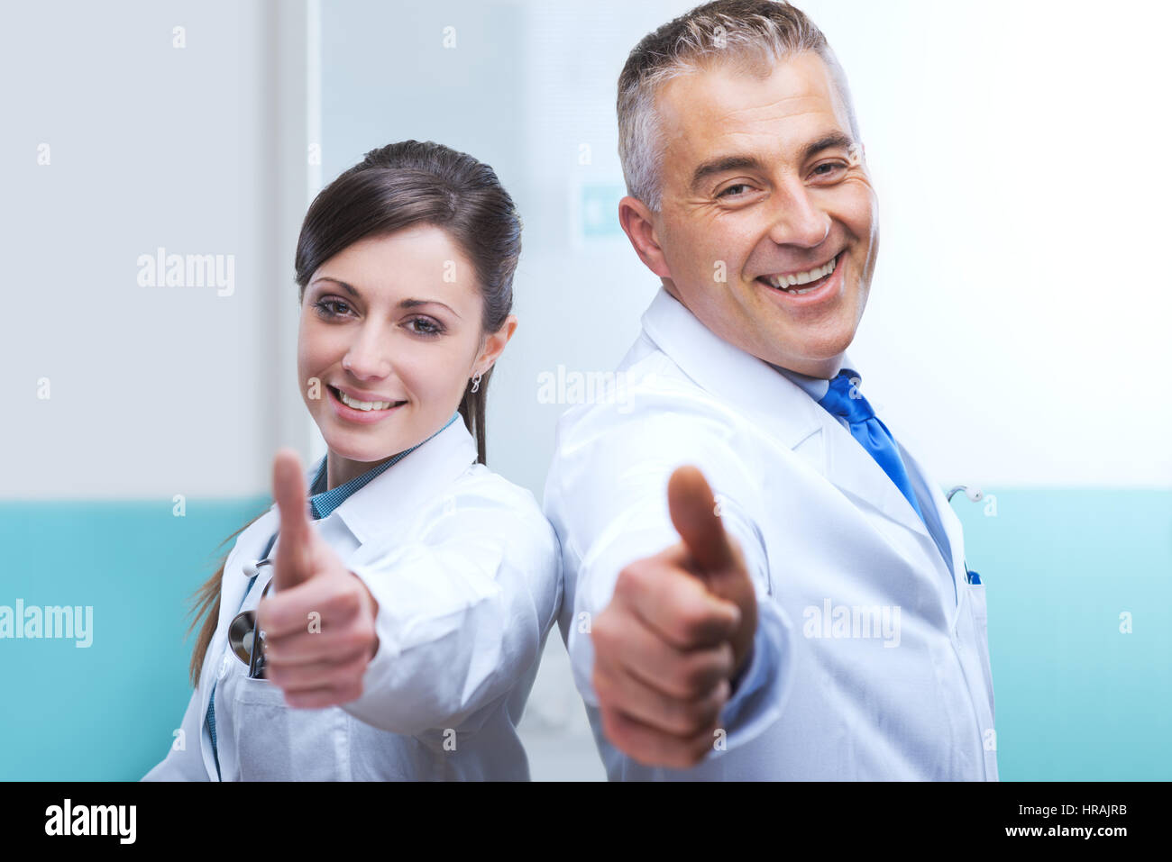 Doctors with thumbs up smiling and expressing vitality Stock Photo - Alamy