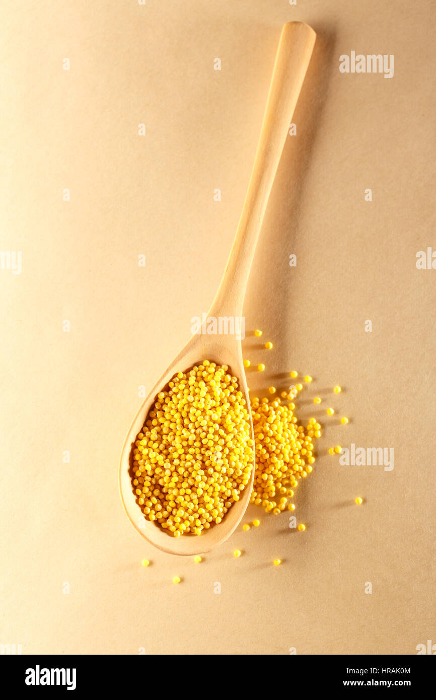 Millet groats with wooden spoon on paper Stock Photo - Alamy
