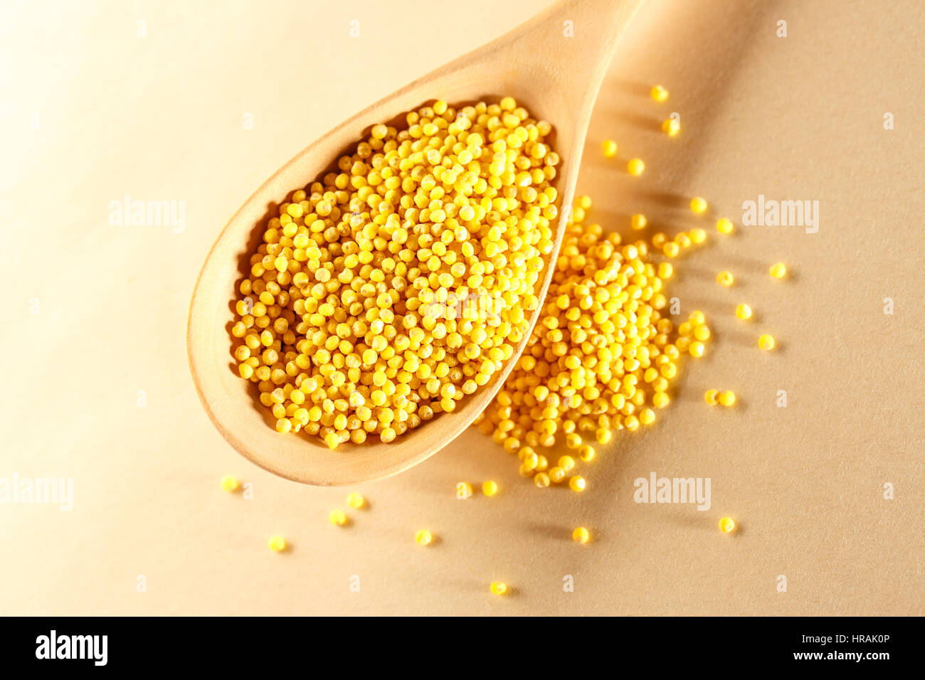 Millet groats with wooden spoon on paper Stock Photo - Alamy