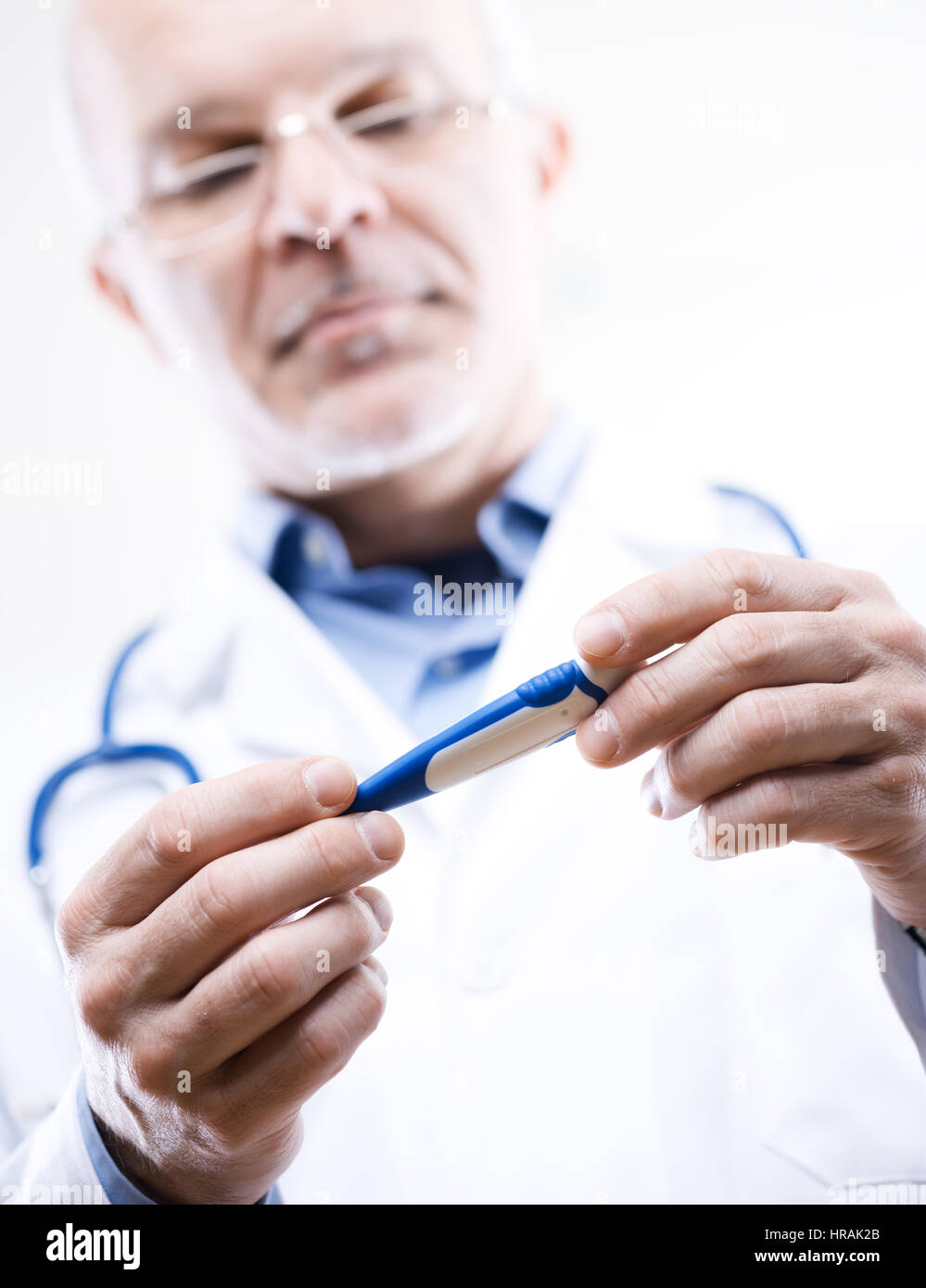 Senior male doctor measuring temperature with a thermometer Stock Photo ...