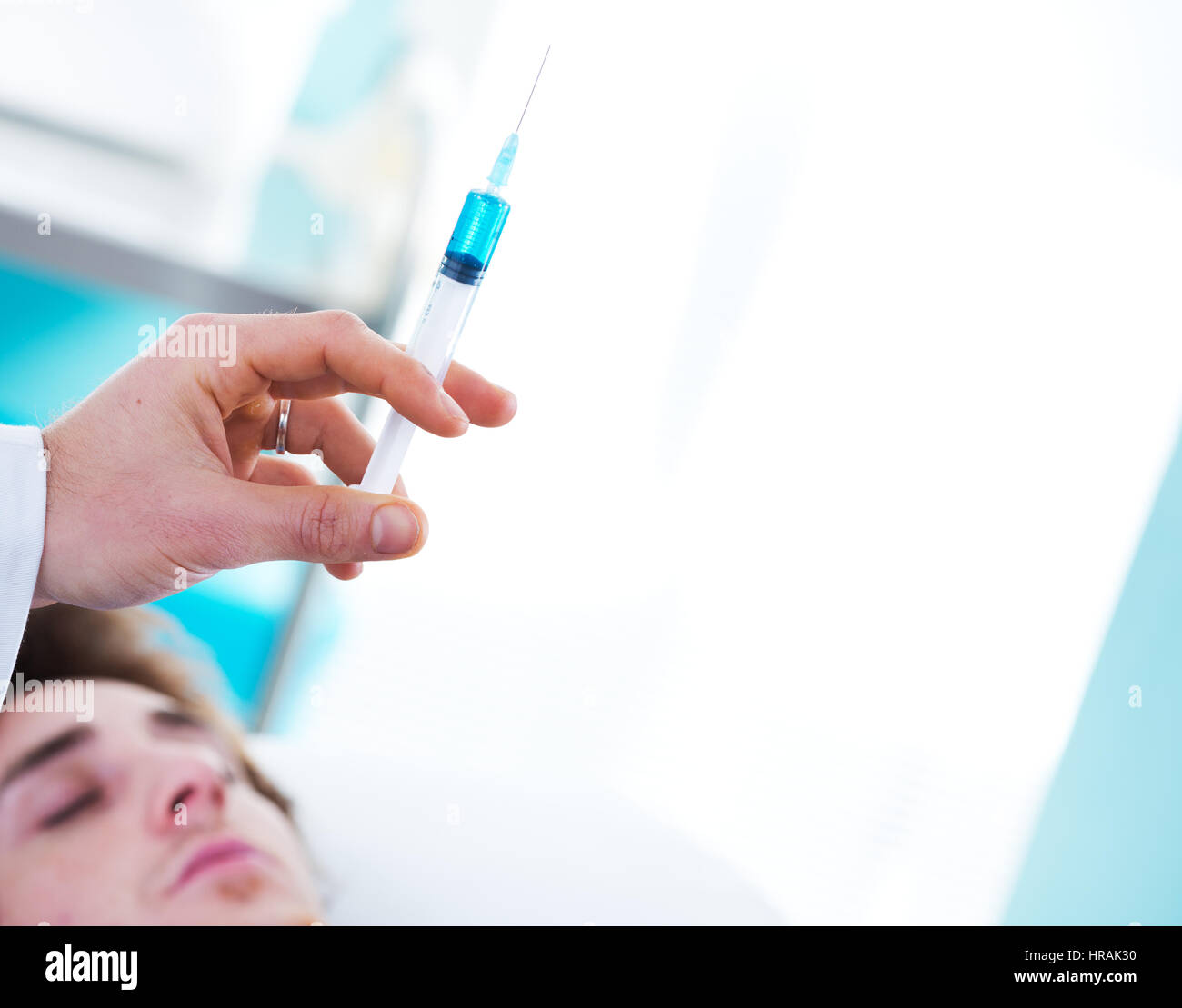 Doctor preparing a syringe for an injection with patient on the ...