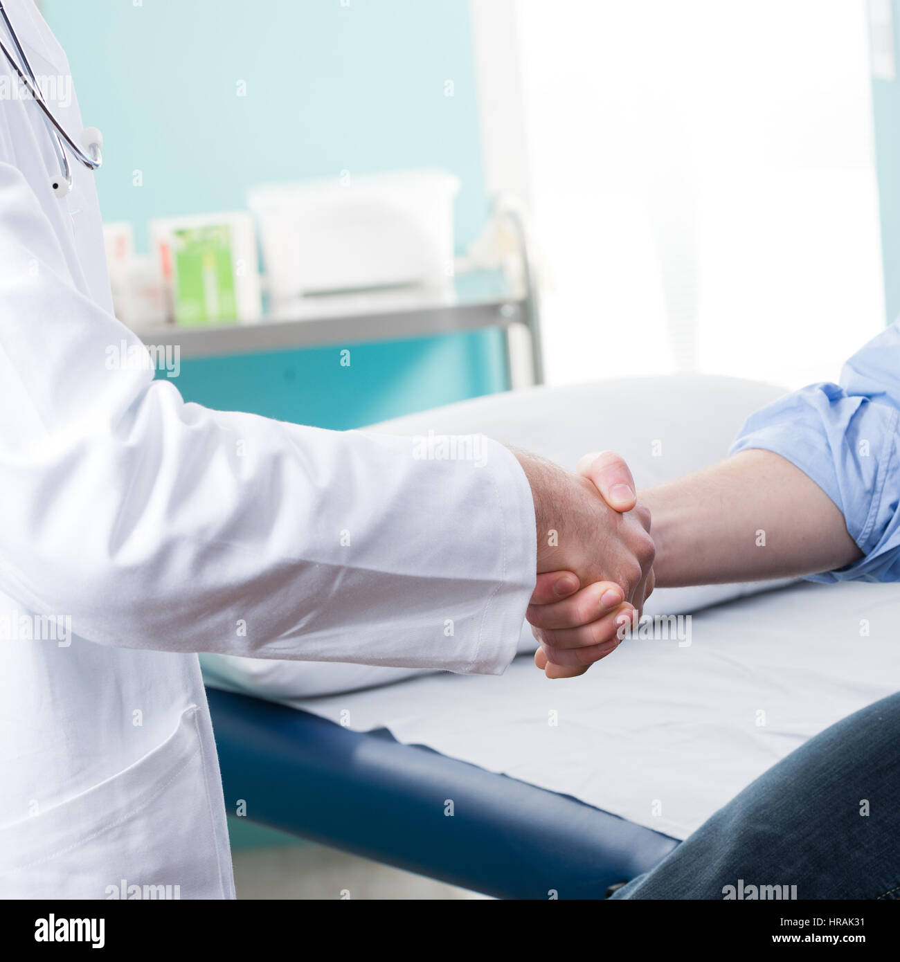 Doctor and patient handshake with medical equipment on the background ...