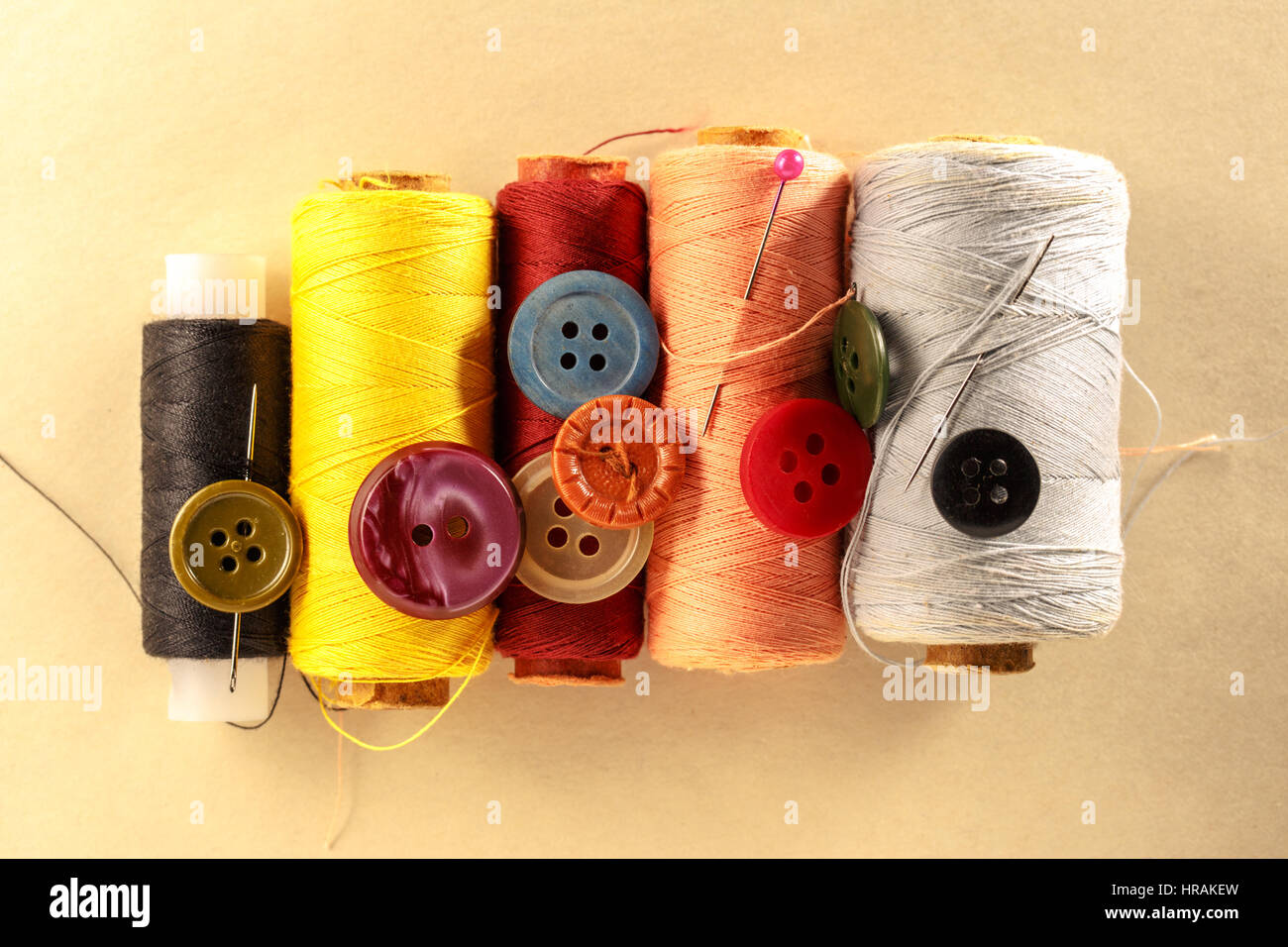 Thread bobbins, buttons and needles on paper background Stock Photo - Alamy