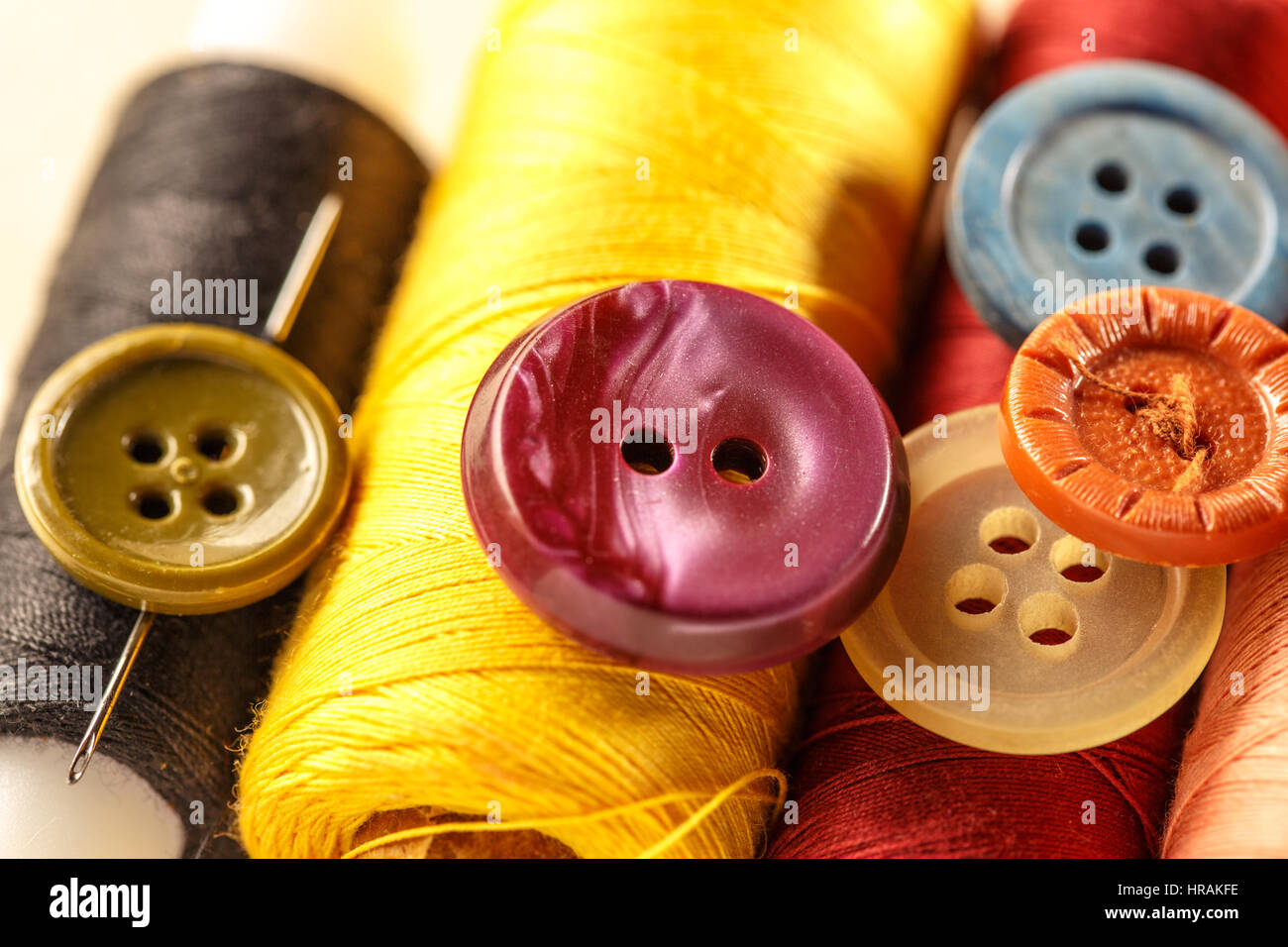 Thread bobbins, buttons and needles on paper background Stock Photo - Alamy