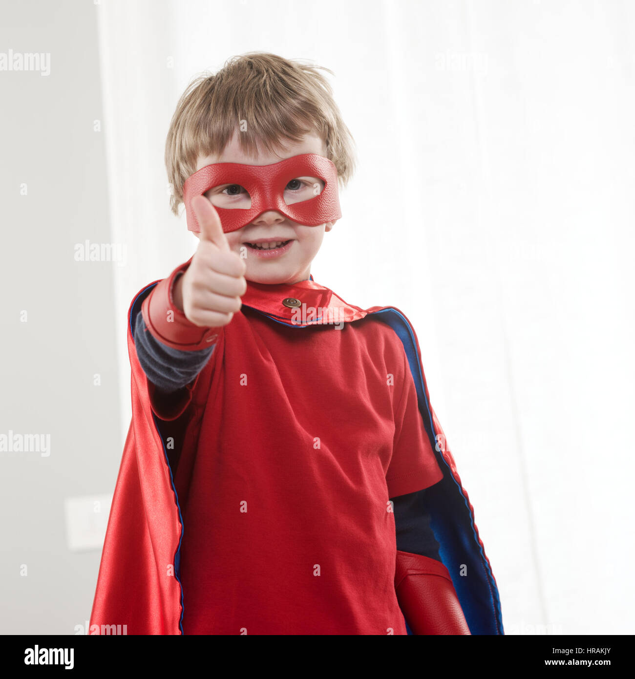 Smiling super hero kid at home with thumb up, looking at camera Stock ...