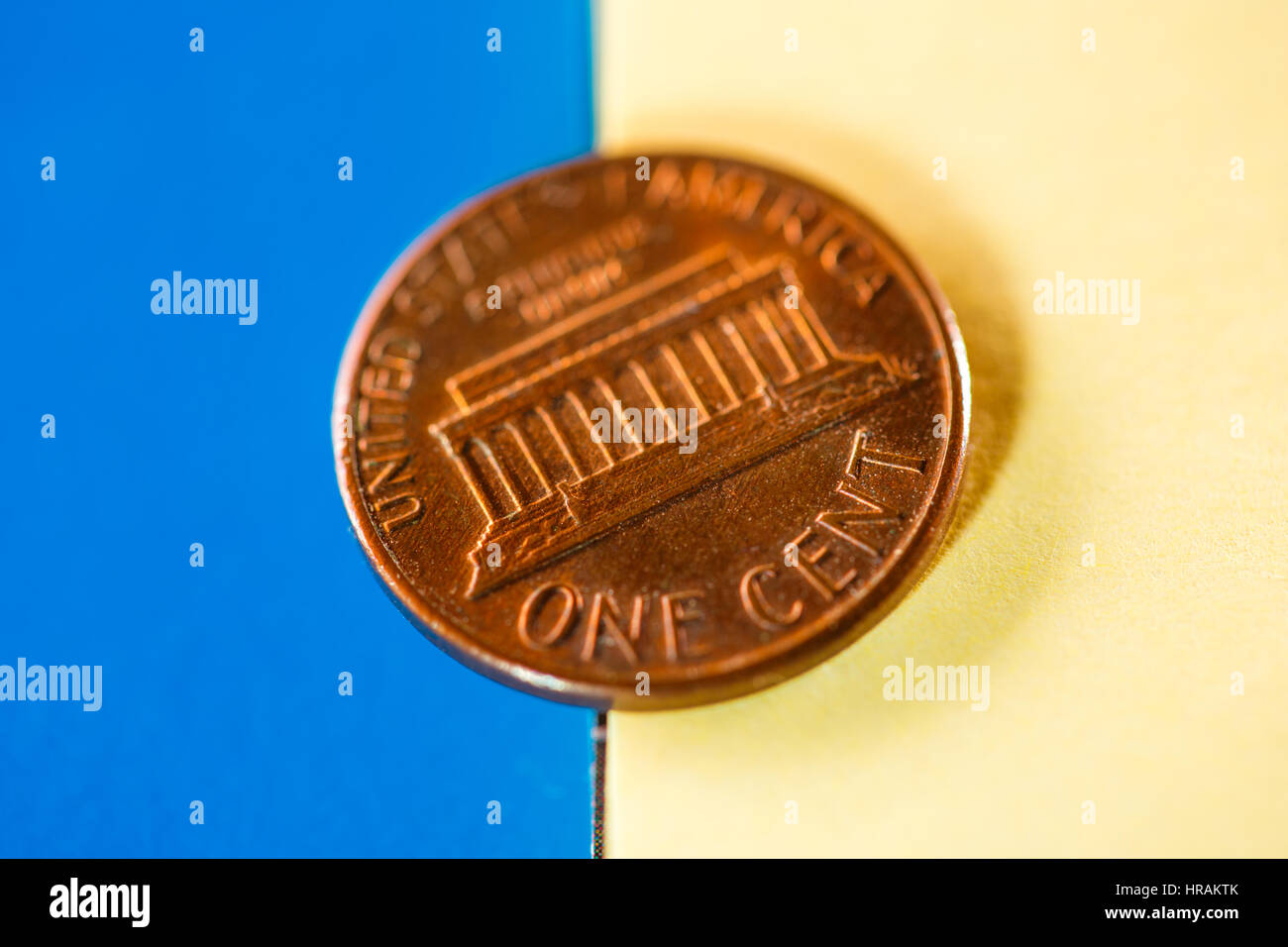 One cent coin in yellow blue background in closeup Stock Photo - Alamy