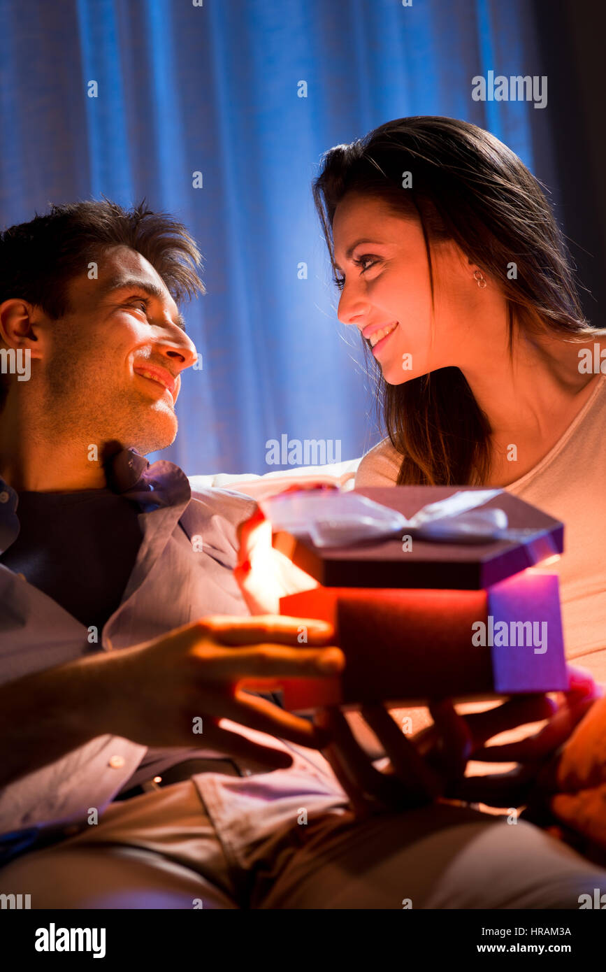 Young woman receiving a surprise gift box from her boyfriend at home ...